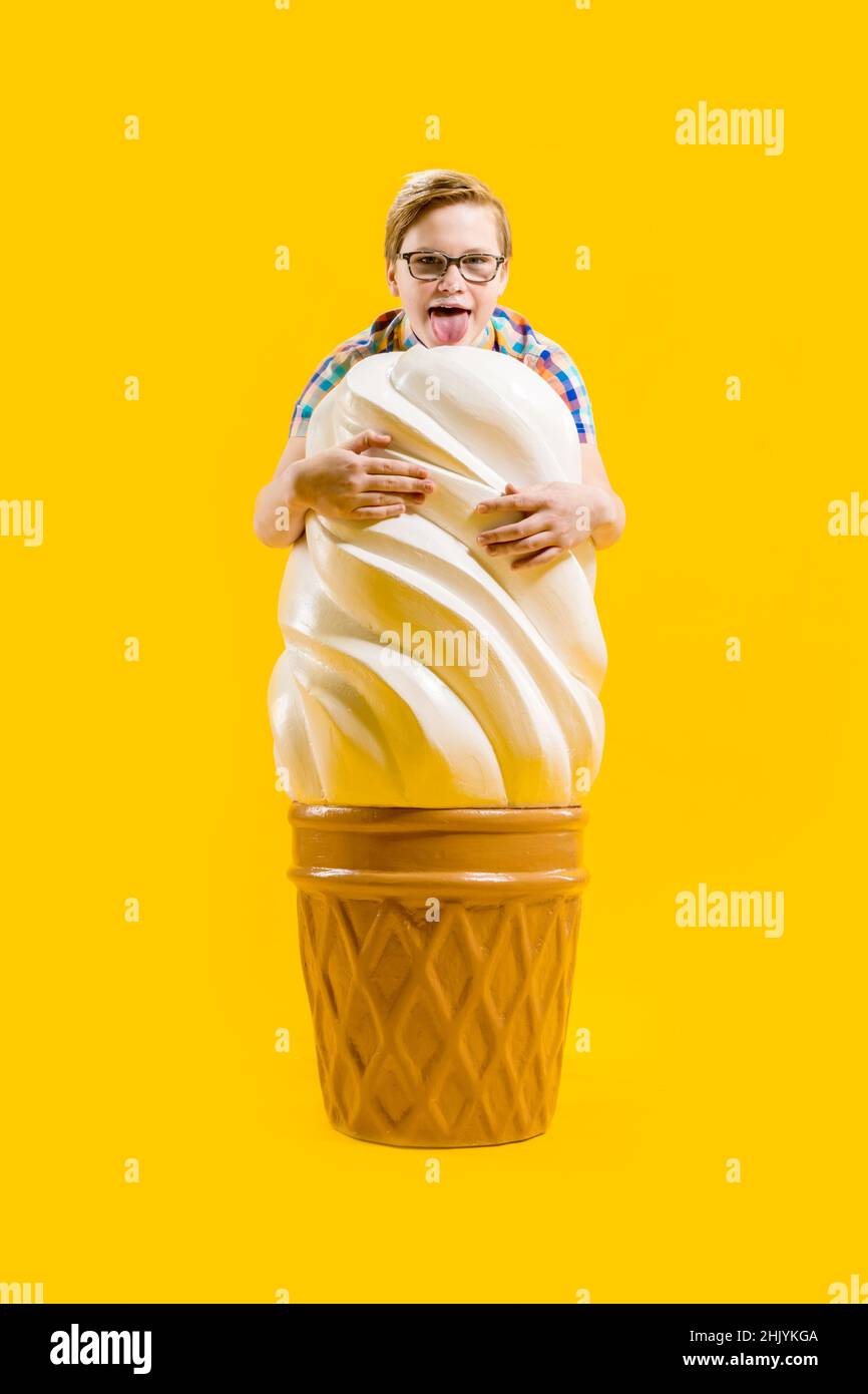 Delicious dessert. Confectionery. Cheerful teenager. A cute boy hugs a ...