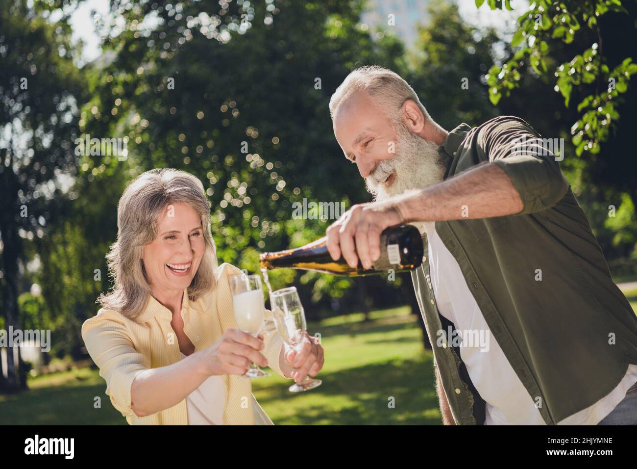 Photo of funky aged couple drink alcohol wear shirt walk in park ...