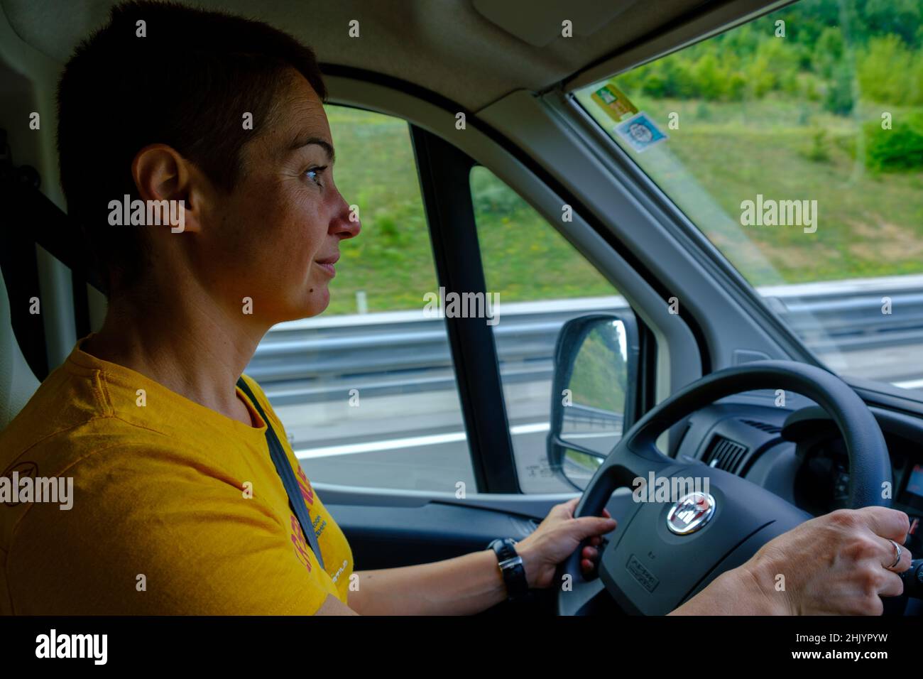 Short haired woman driving a camper van Stock Photo - Alamy