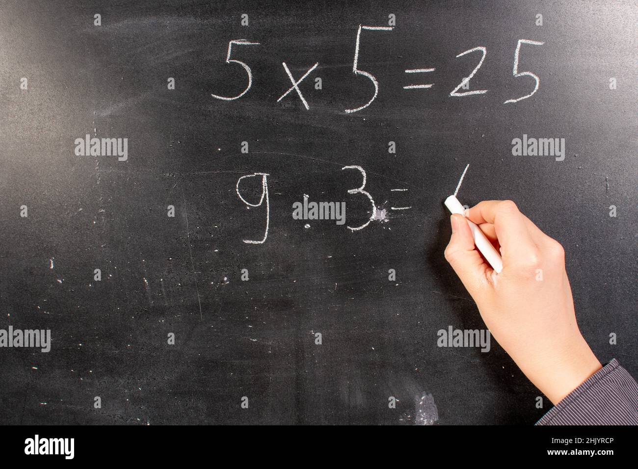 Boy calculates and writes on a blackboard Stock Photo - Alamy