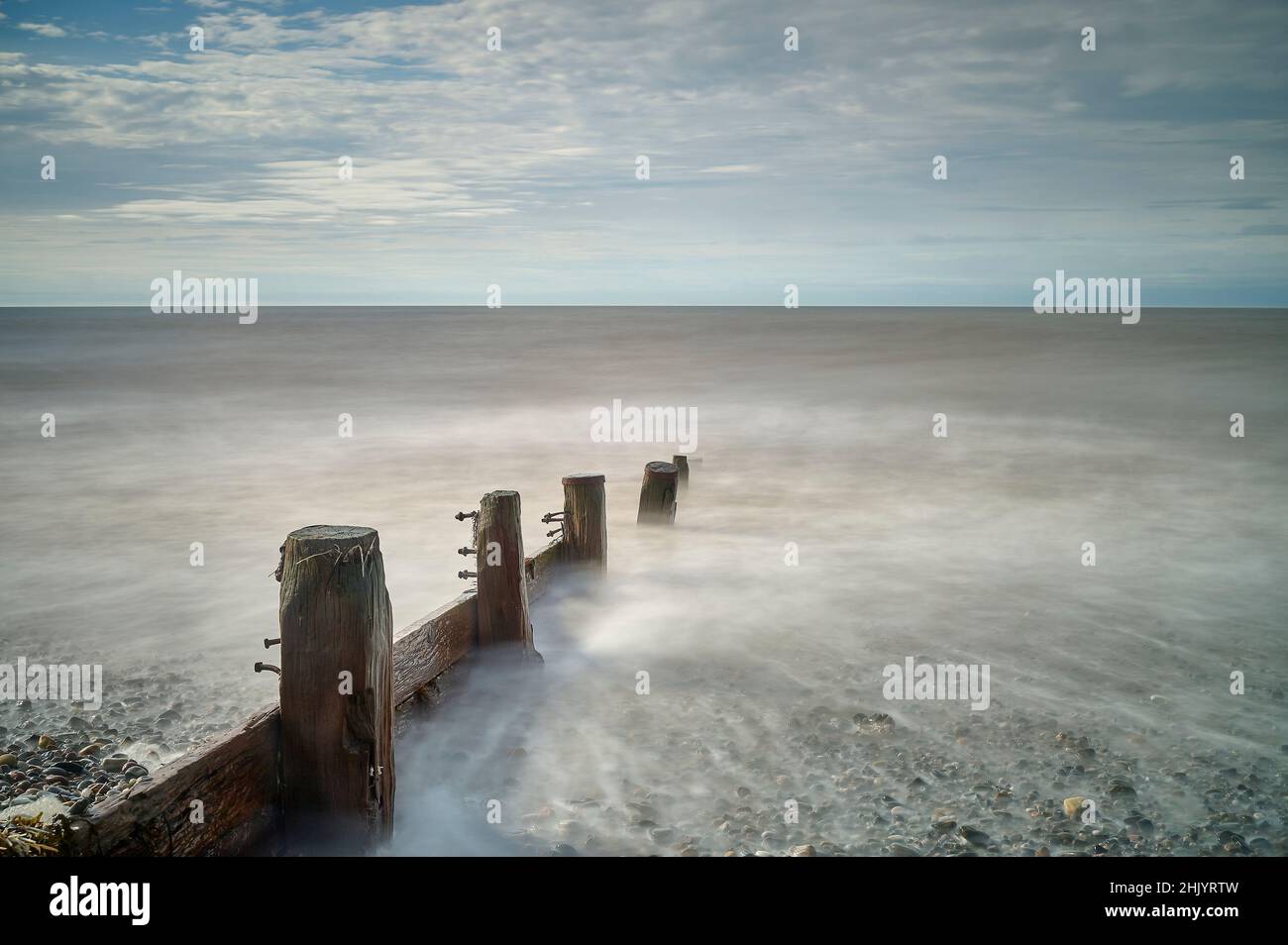 Long exposure of sea coming in on to shingle beach Stock Photo - Alamy
