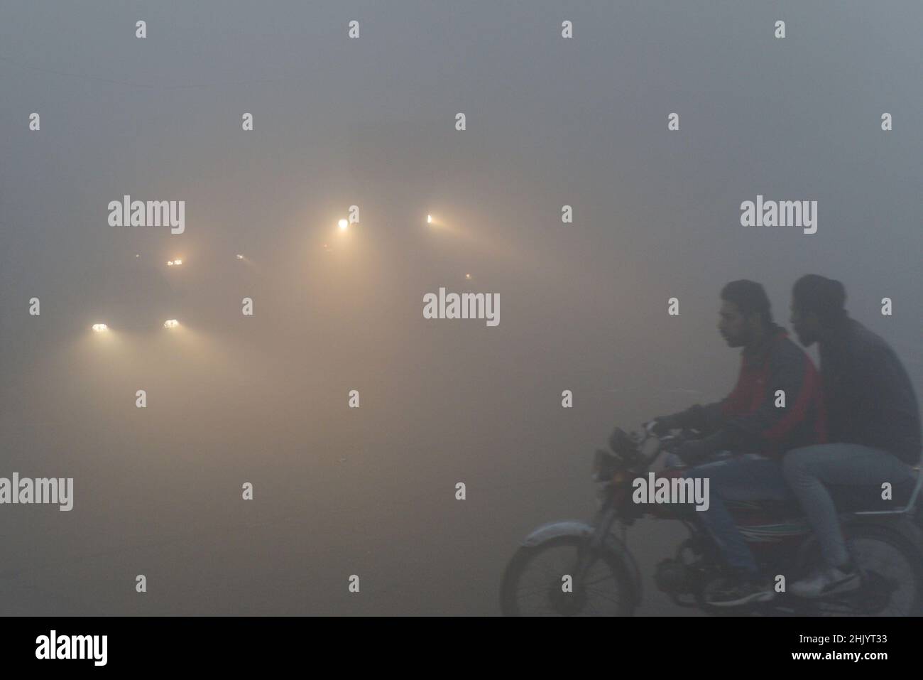 Pakistani citizens and students on their way during a cold and dense ...