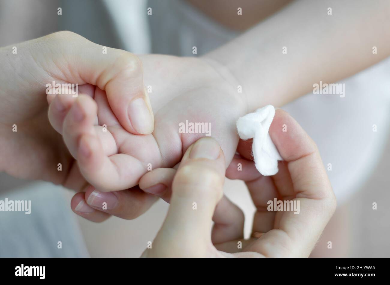 The woman is trying to pull the splinter out of the child's hand. A ...