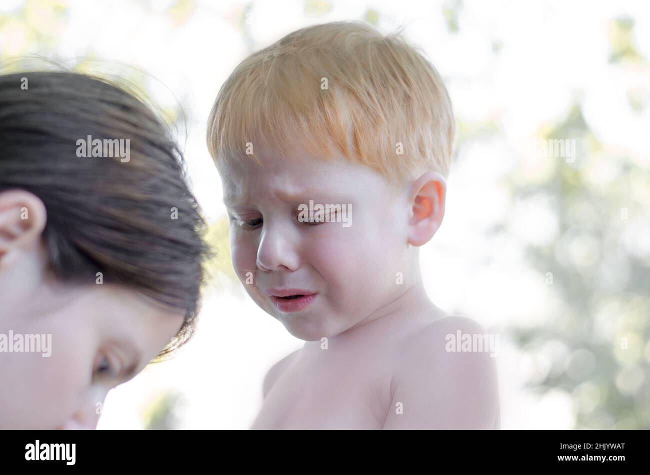 A 4-year-old boy cries while his mother pulls out a splinter. Redhead ...