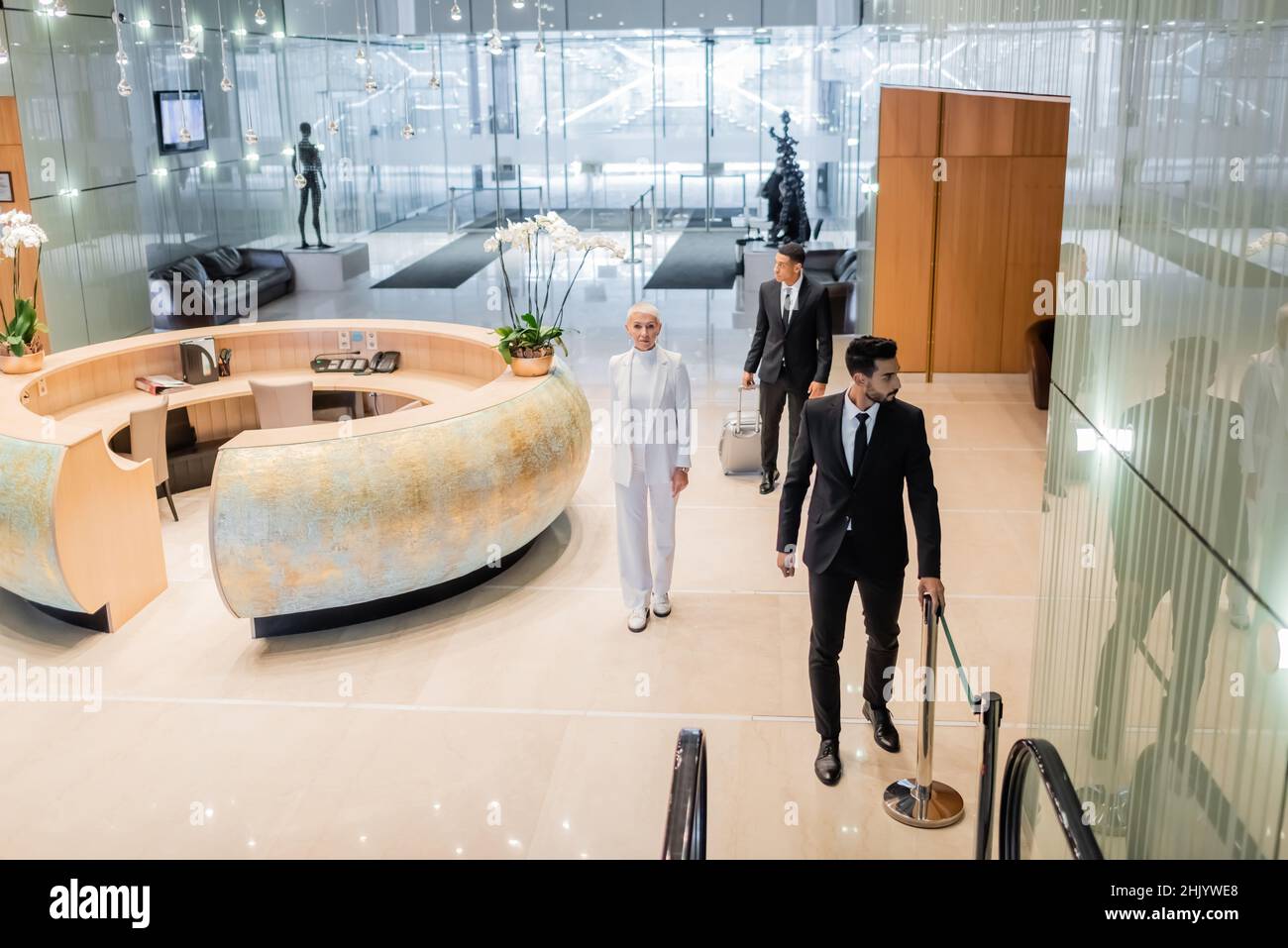 high angle view of multiethnic bodyguards in formal wear escorting ...