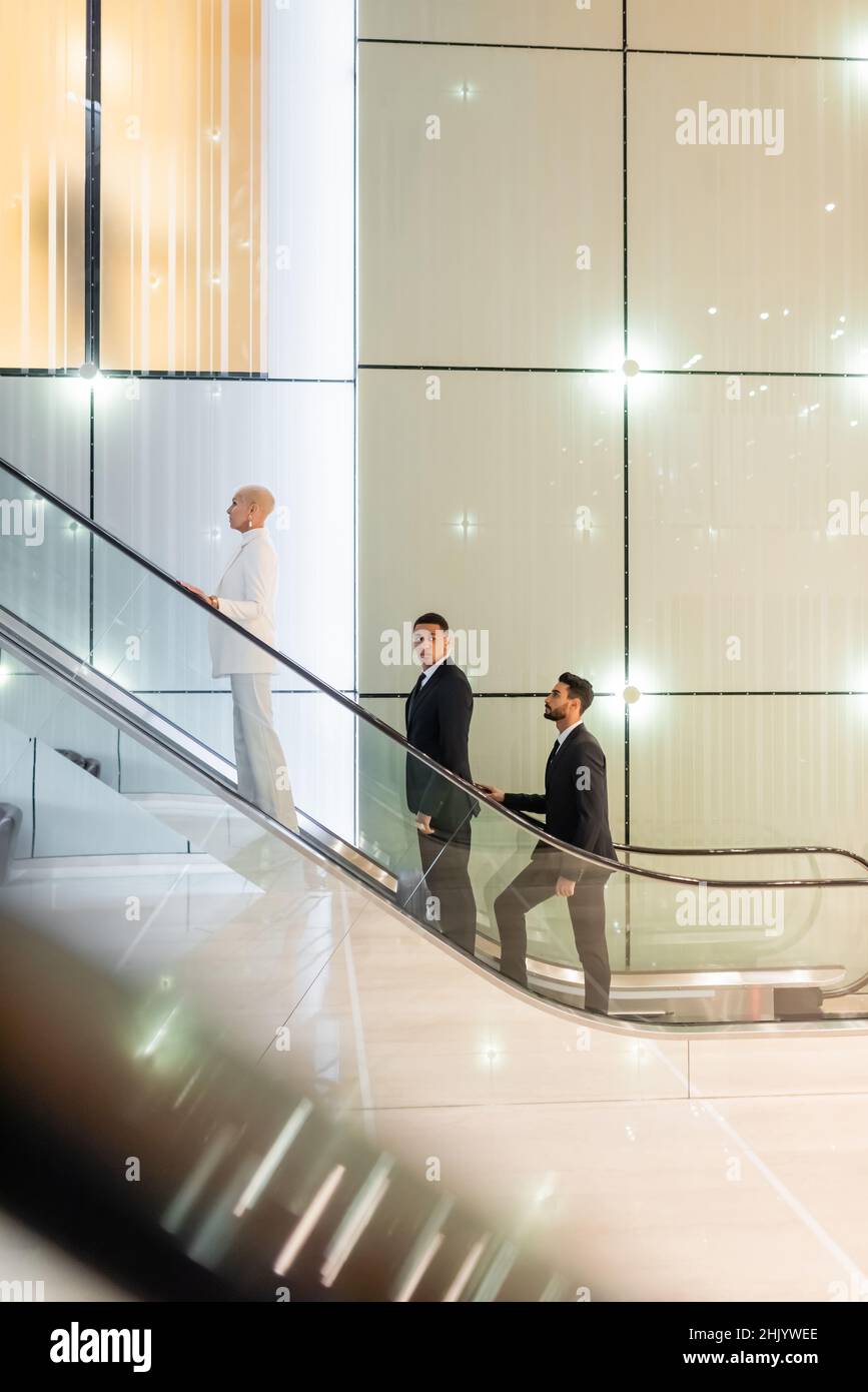 senior business lady near private bodyguards in formal wear on hotel ...
