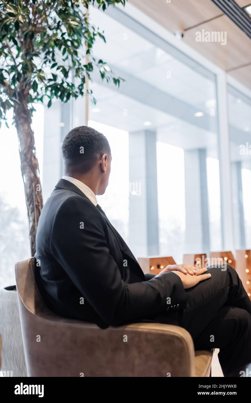 african american man in black suit sitting in hotel lounge Stock Photo ...