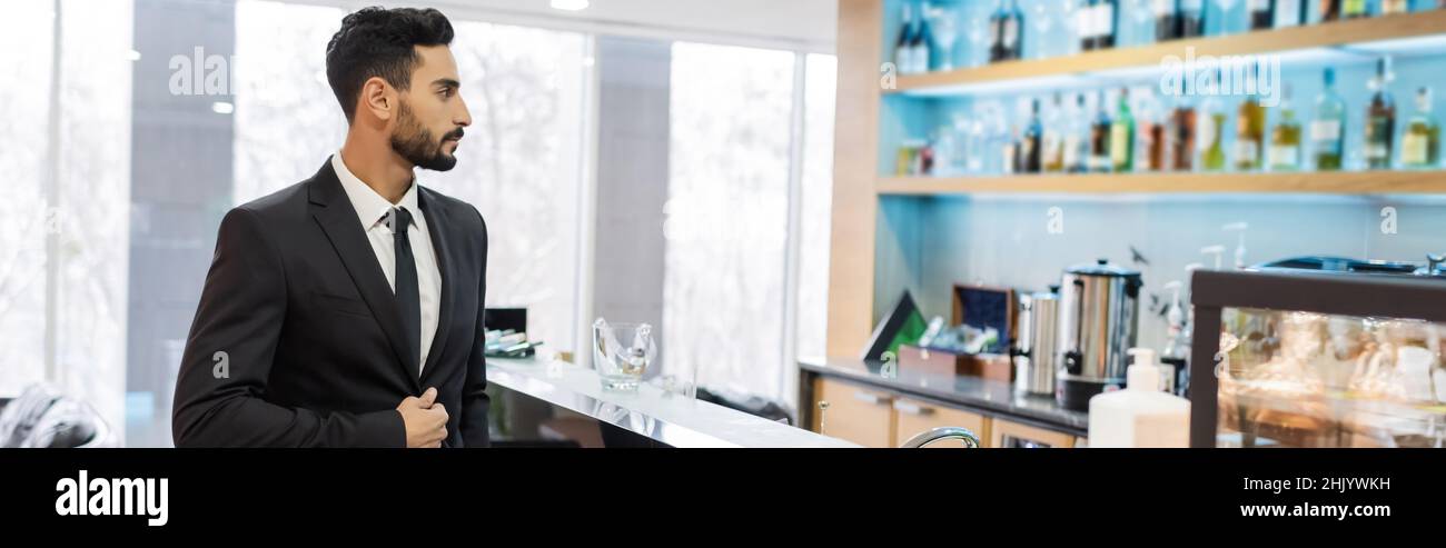 bi-racial security man in suit standing at bar counter in hotel lobby ...