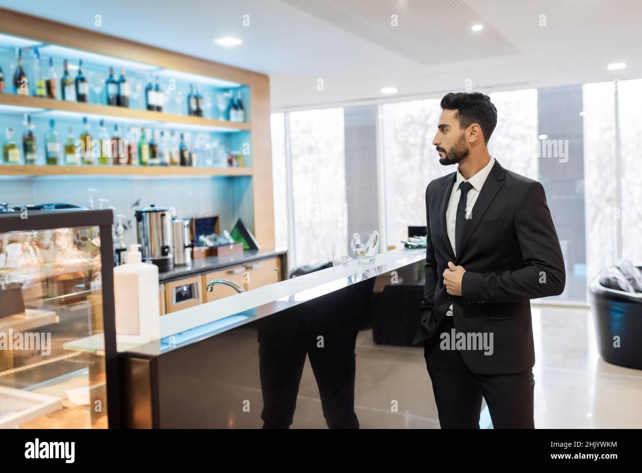 mixed-race security man standing near bar counter in hotel lobby Stock ...