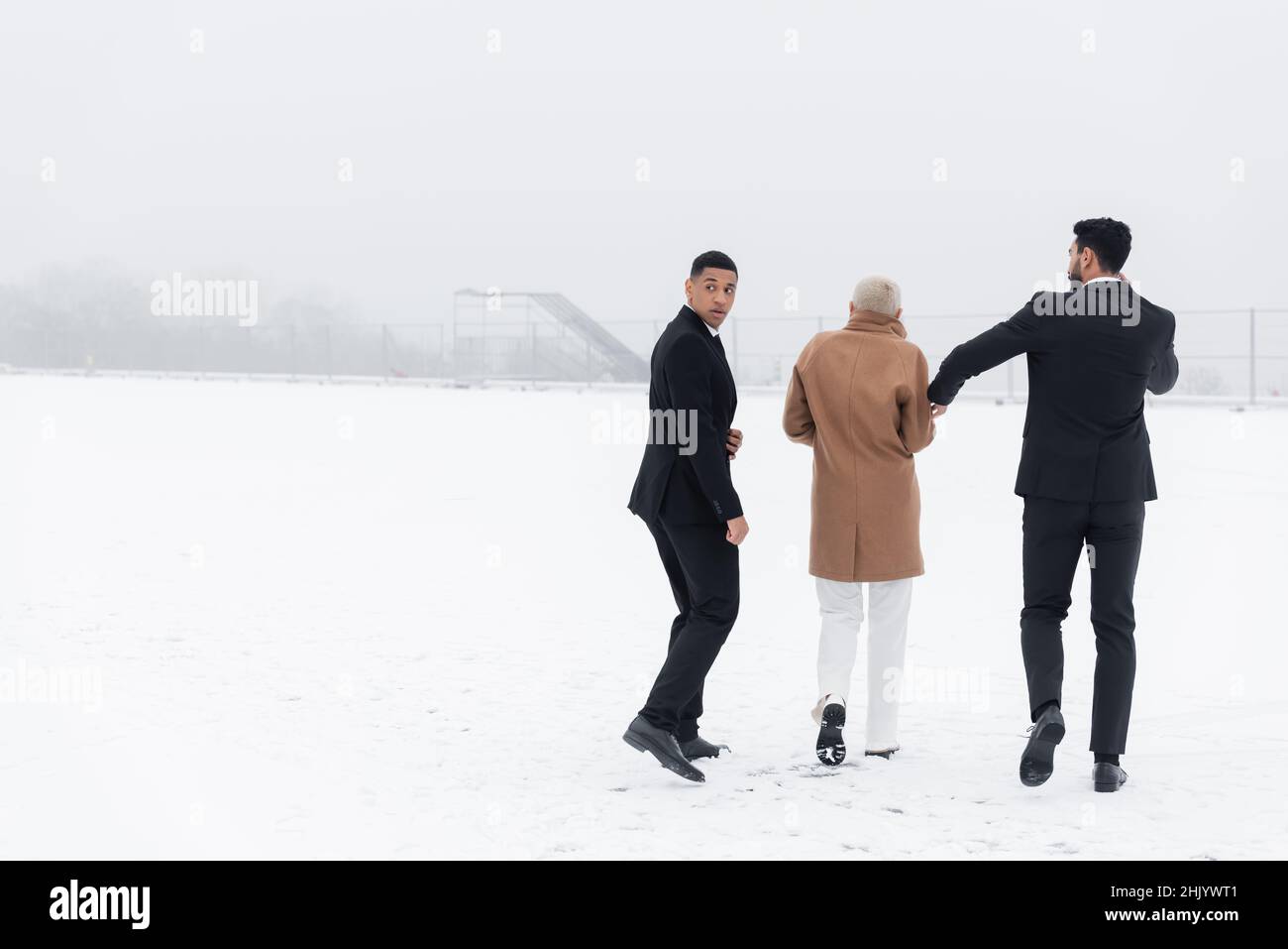 african american security man looking back while walking near senior ...
