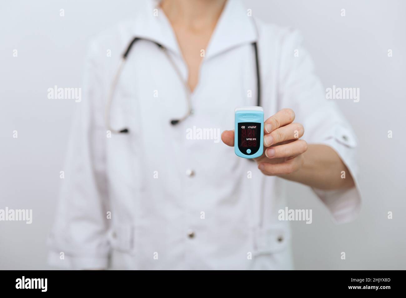 Pulse oximeter with hand of doctor isolated on white. The concept of ...