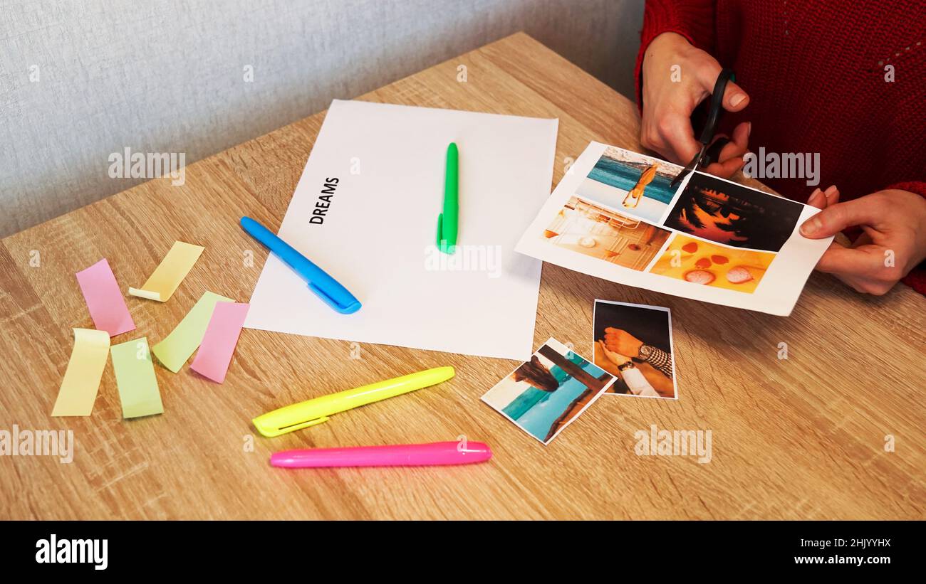 Young woman creating Feng Shui wish map using scissors. Blond cut out ...
