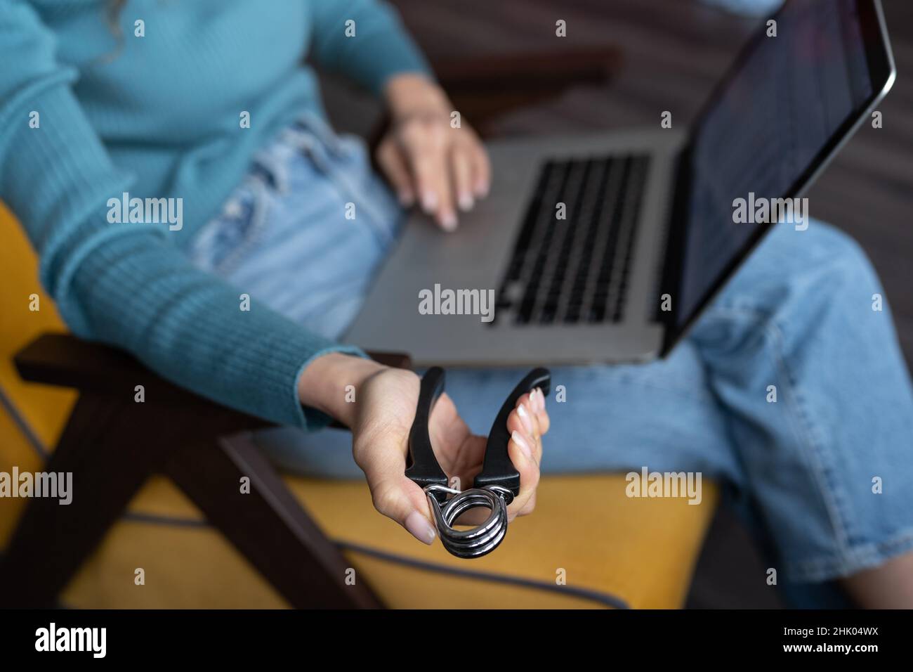 Female office worker using laptop and compressing adjustable hand ...