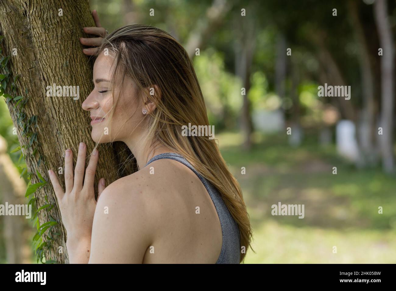 Portrait of smiling young woman at a park on a beautiful sunny day ...