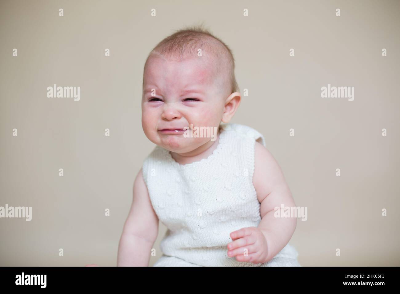 Close portrait of cute little baby boy, isolated on beige background ...