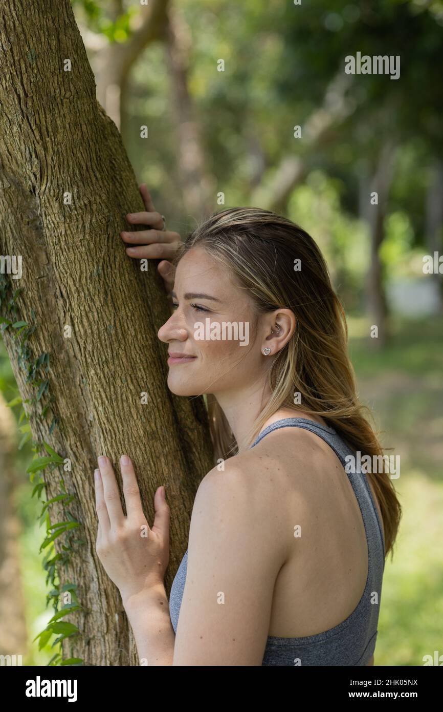 Portrait of smiling young woman at a park on a beautiful sunny day ...