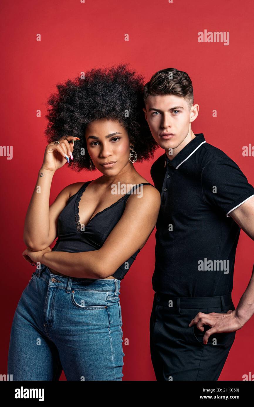 Multiracial couple studio shooting over a red background Stock Photo ...
