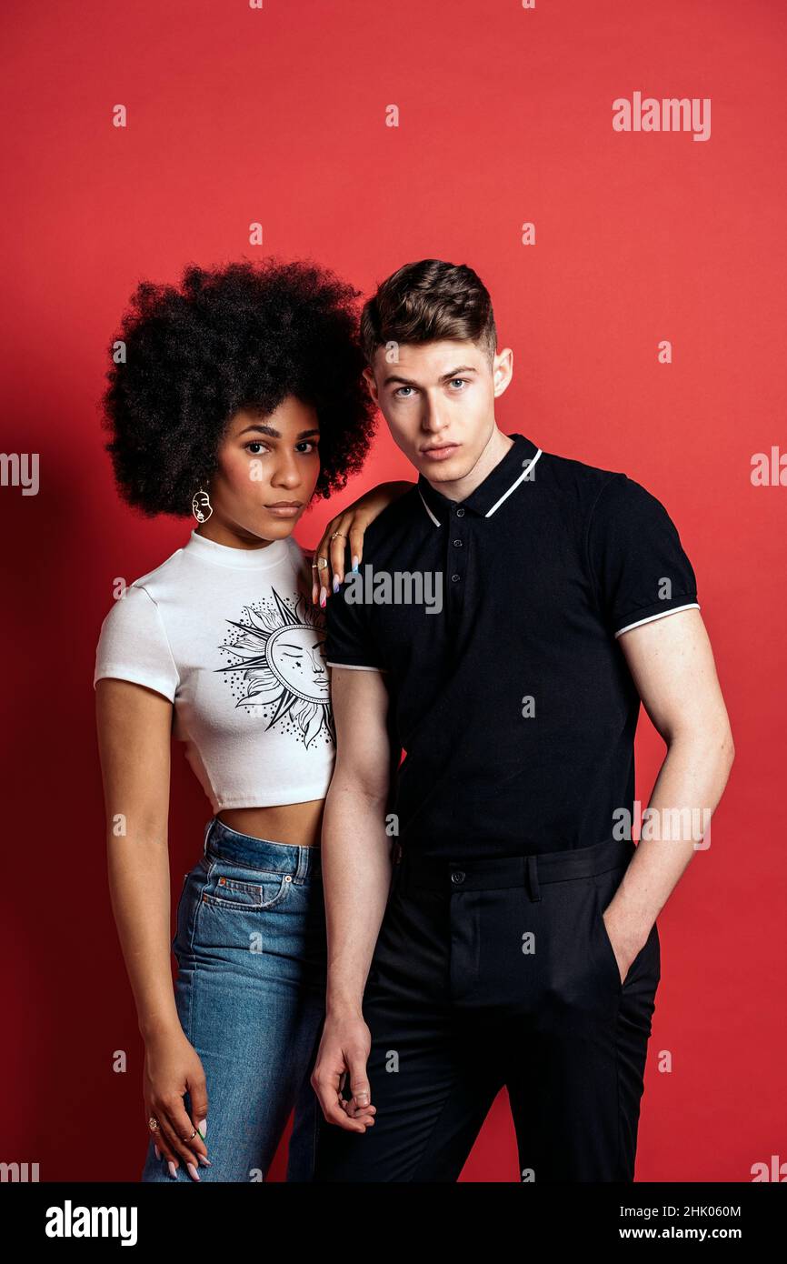 Multiracial couple studio shooting over a red background Stock Photo ...