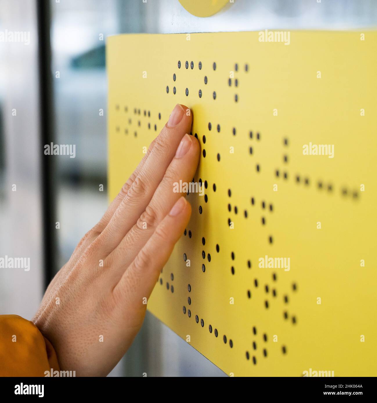Close-up of a woman reading a braille lettering on a glass door Stock ...