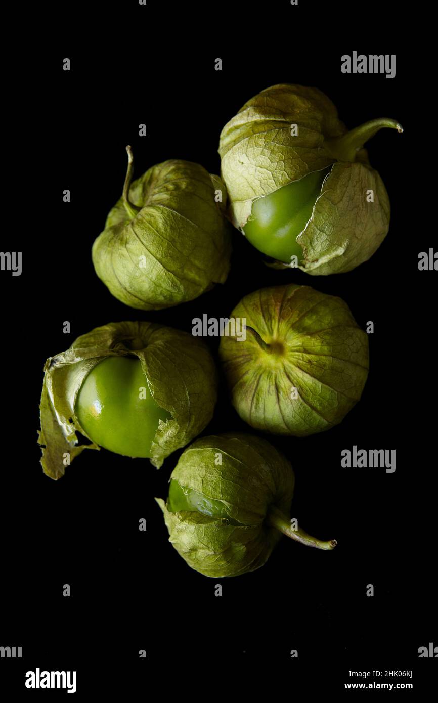 Tomatillo Green Husk Tomatoes on Black Background Stock Photo - Alamy