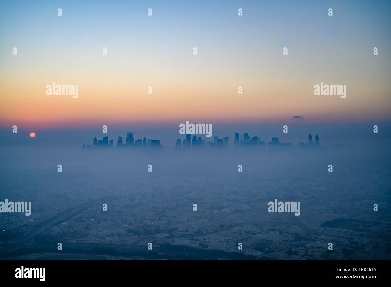 Doha skyline at sunrise with morning fog Stock Photo - Alamy