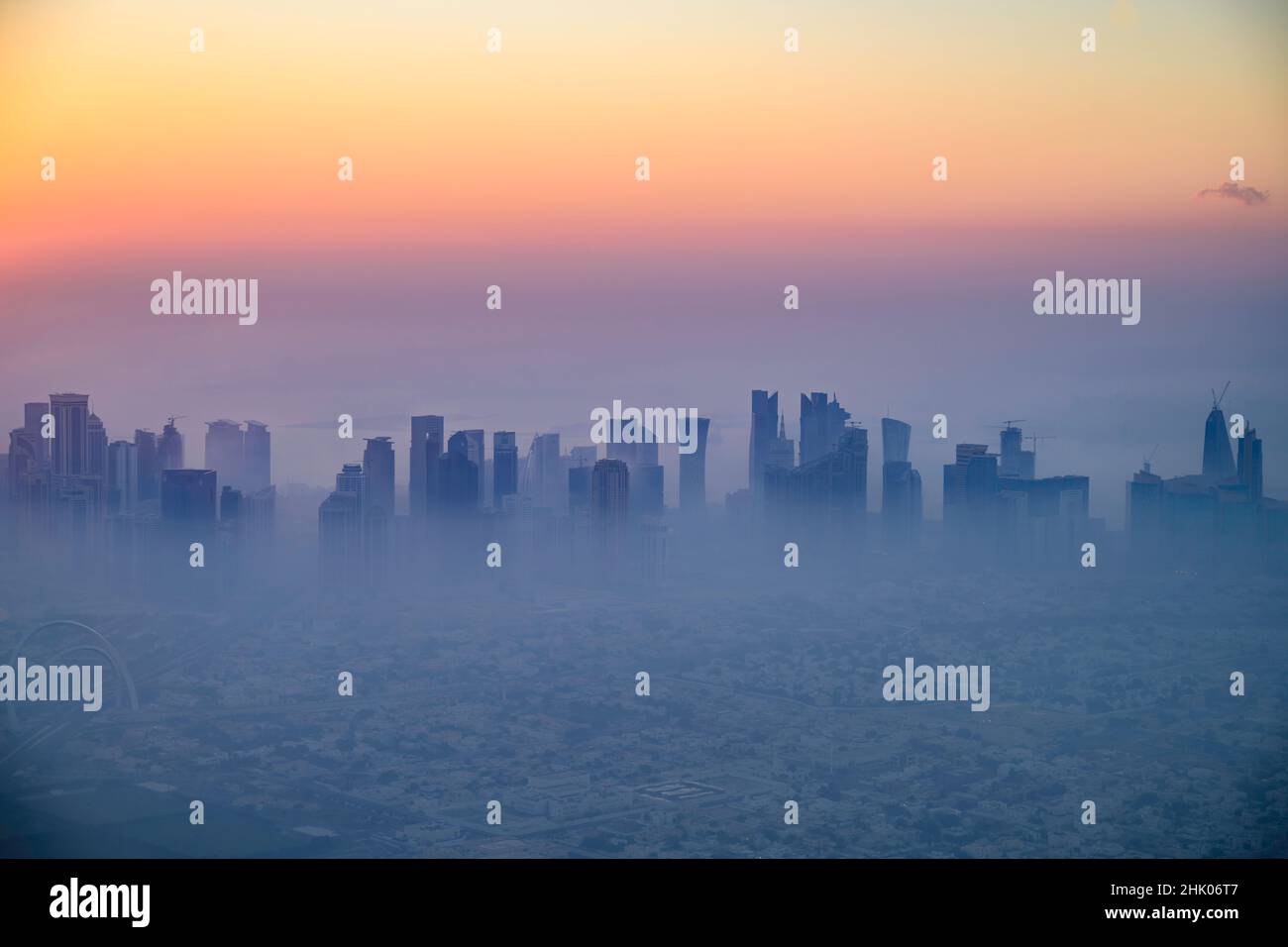 Doha skyline at sunrise with morning fog Stock Photo - Alamy