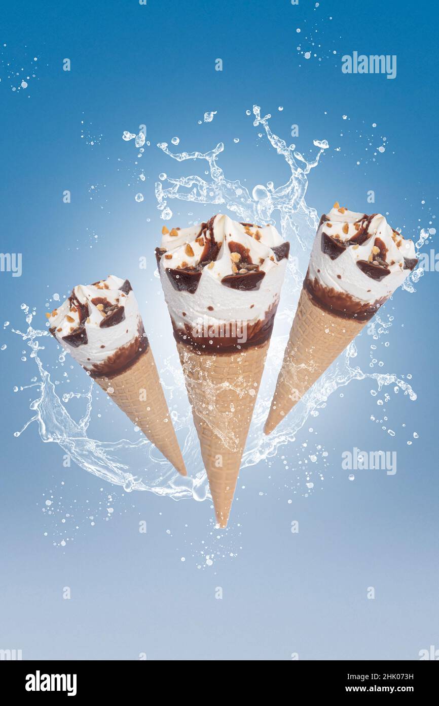 Flying ice cream cones with splash on blue background. Vertical format ...