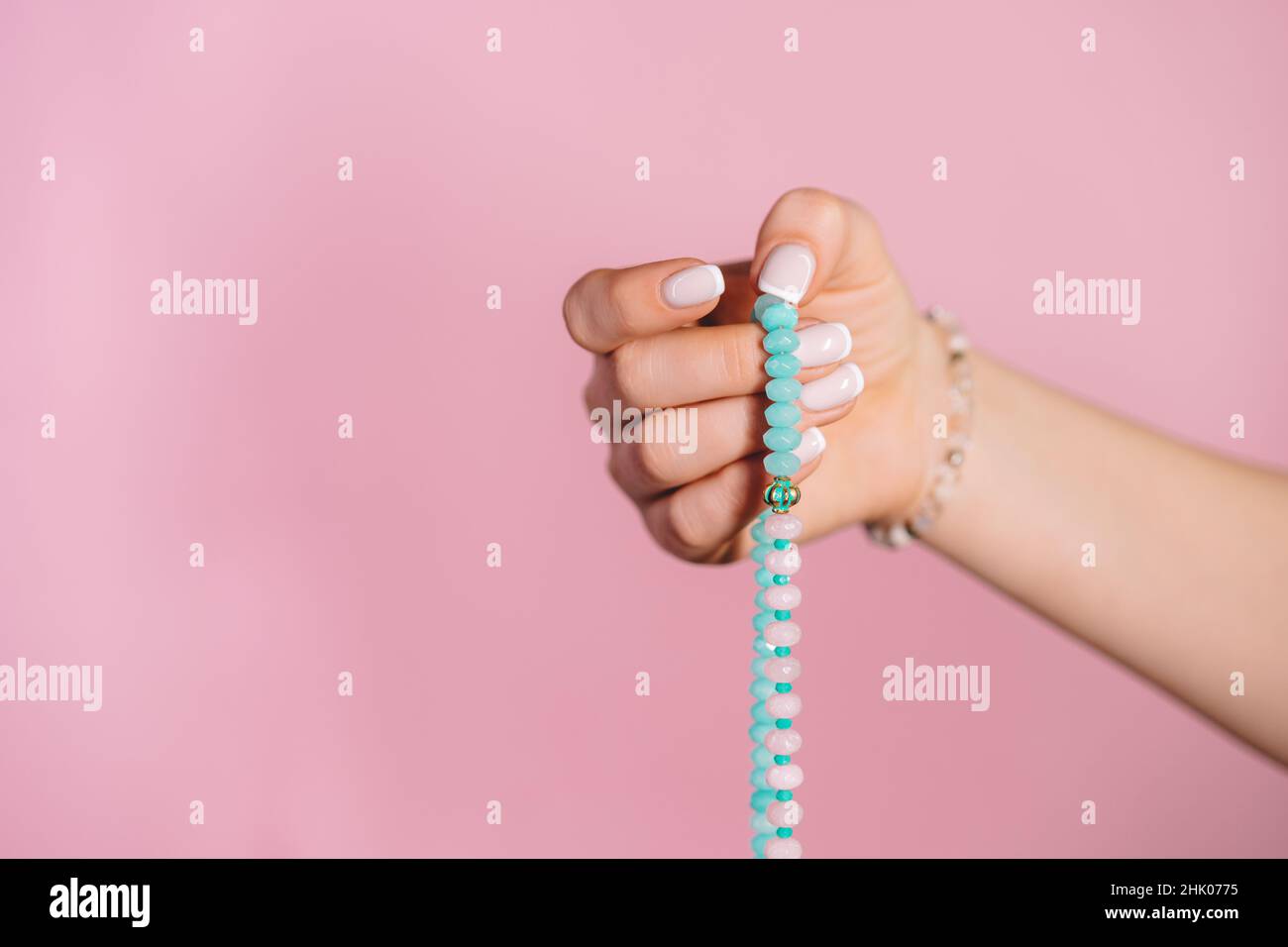 Woman lit hand counts mala beads strands of gemstones used for keeping ...