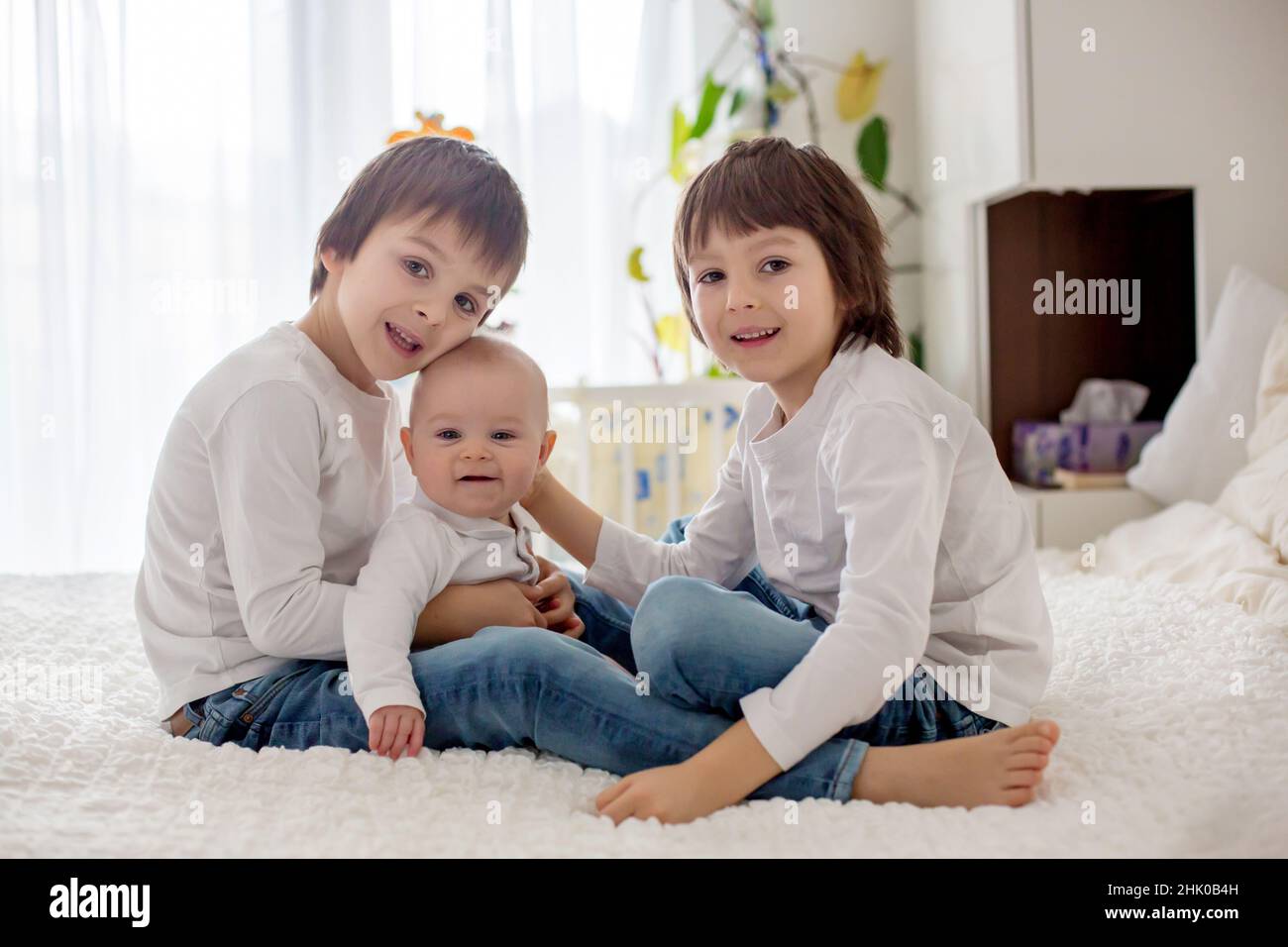 Little toddler and preschool boys, playing with their little brother at ...