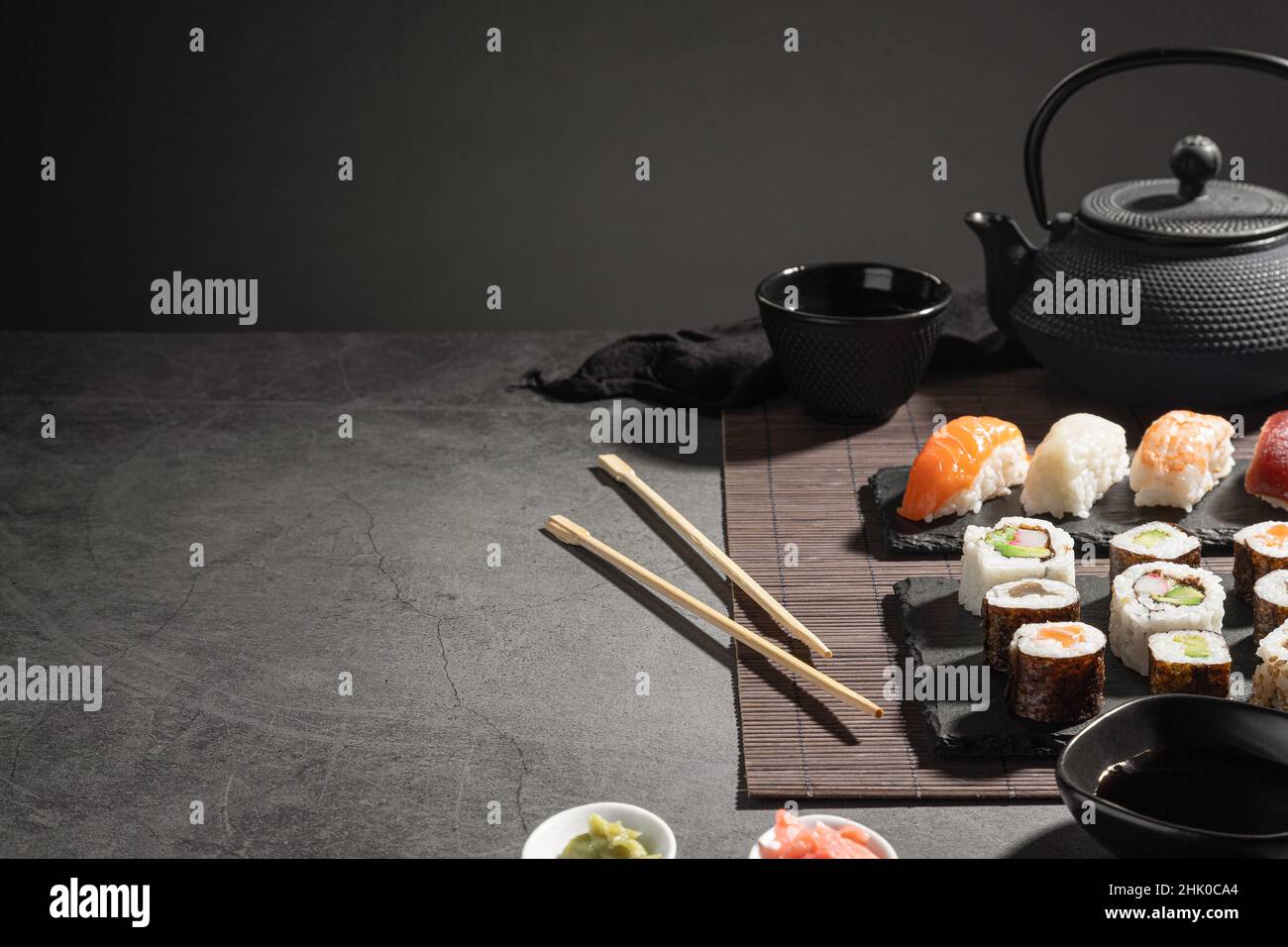 Variety of Fresh sushi and japanese tea on dark background. with ...