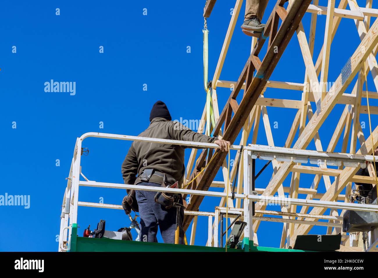 Man builds wooden structure for house with man hammers nails into ...