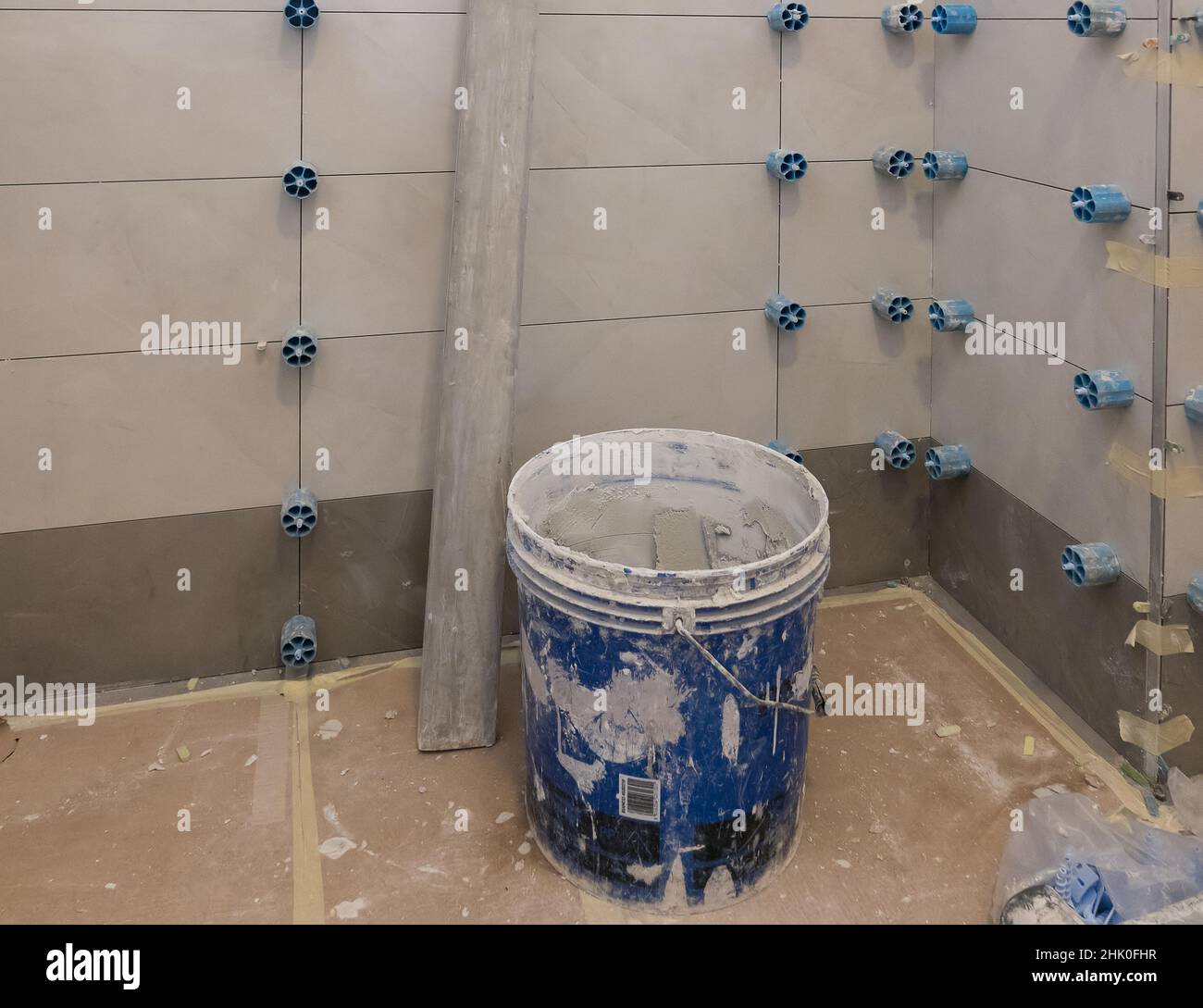 Tiles fixing on the walls of a renovated toilet Stock Photo - Alamy
