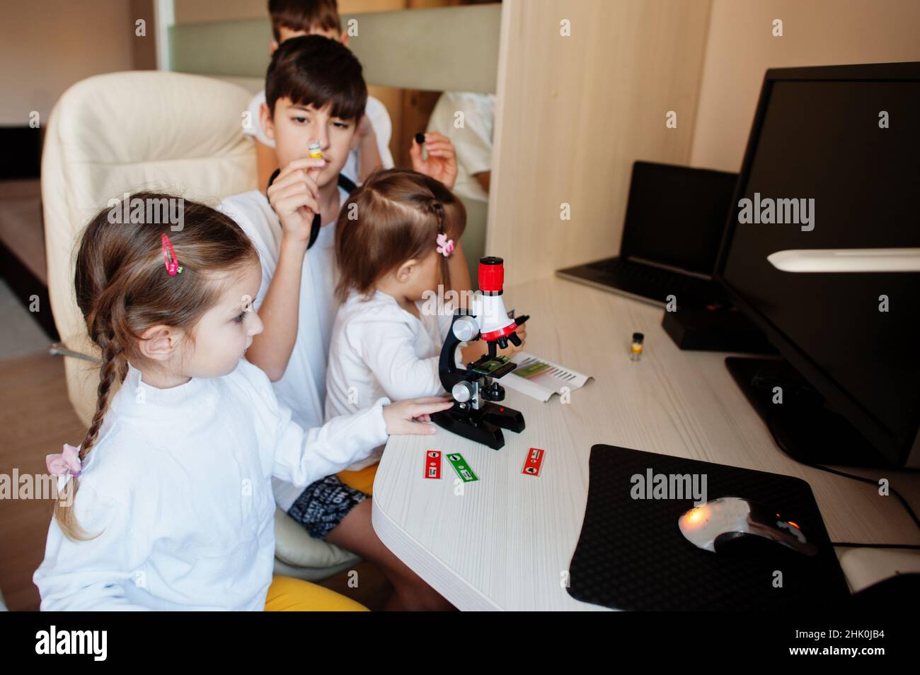 Kids using microscope learning science class at home Stock Photo - Alamy