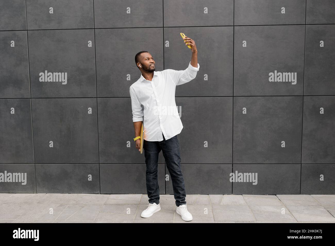 Stylish dressed male employee or student using smartphone, having video ...