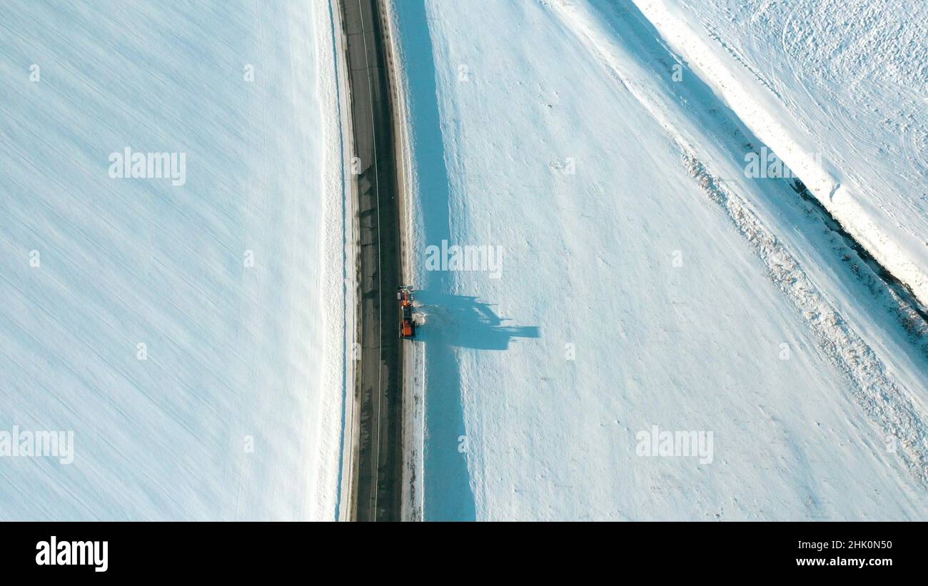 Aerial View Snow Removal Tractor Clears Road From Snow. Bird's Eye View ...