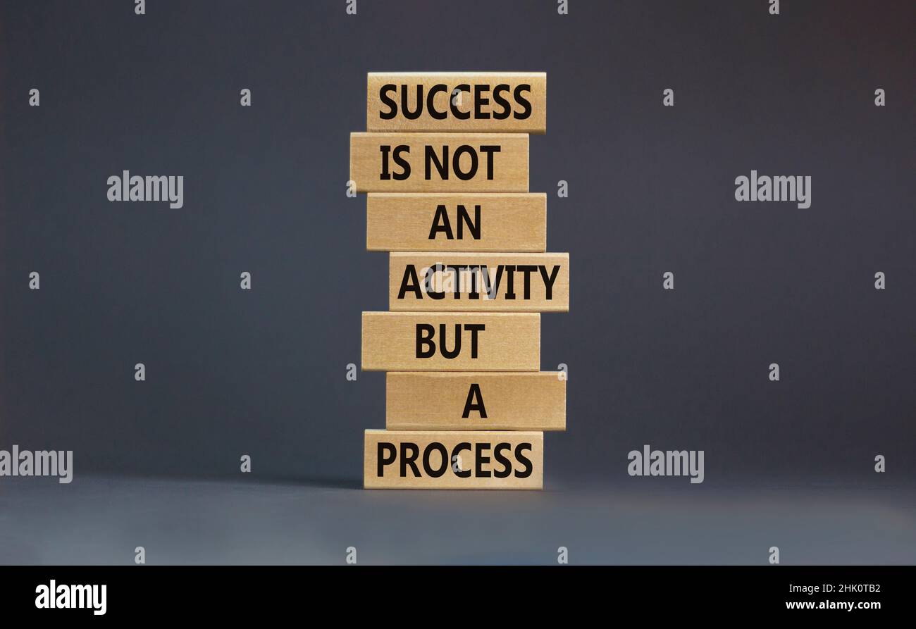 Success in process symbol. Wooden blocks with words Success is not an ...