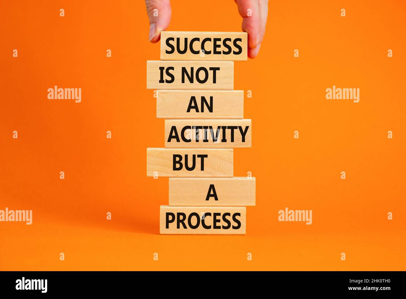 Success in process symbol. Wooden blocks with words Success is not an ...
