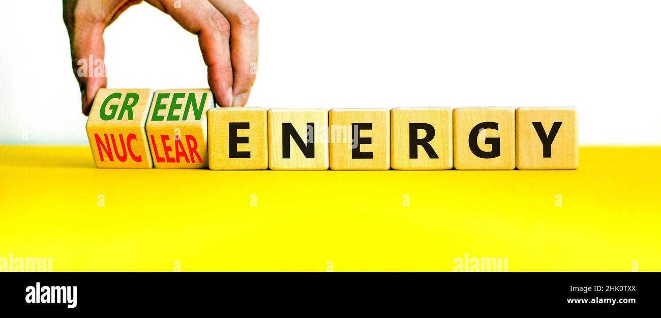 Nuclear or green energy symbol. Businessman turns wooden cubes and ...