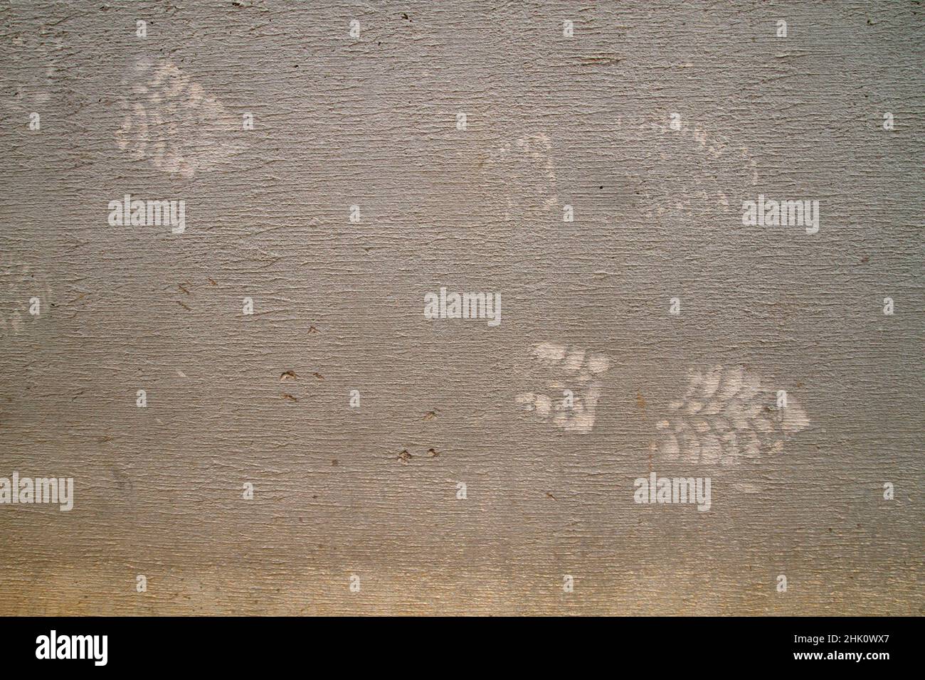 Work boots footprints on gray plastered wall, grunge texture or ...