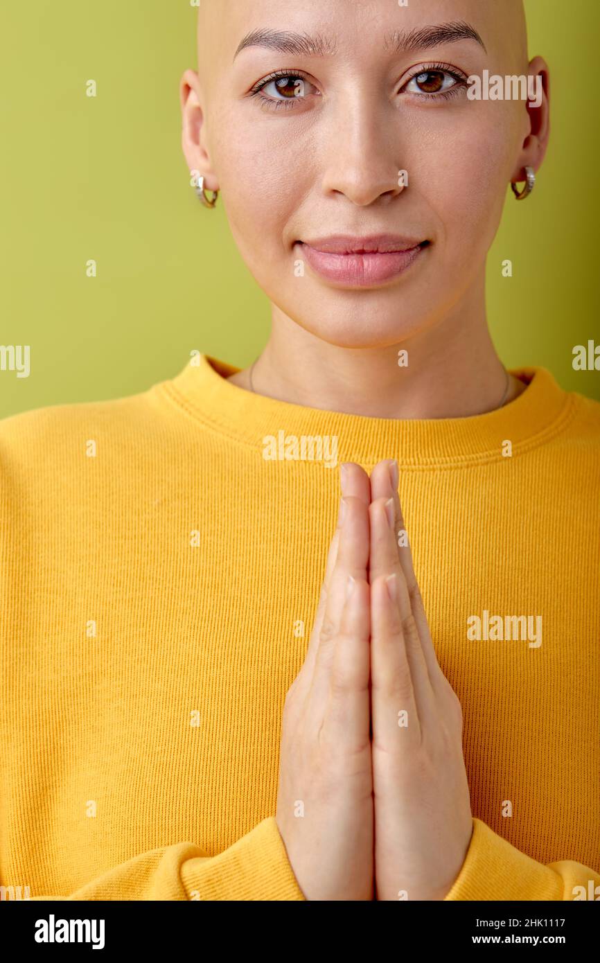 calm and gorgeous young bald woman with smiling face posing at camera ...