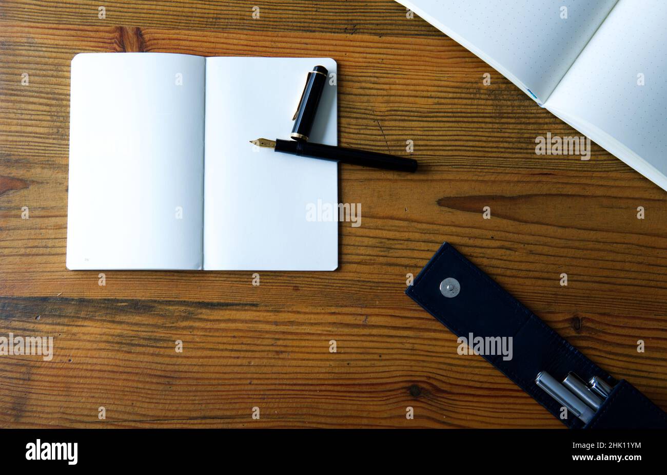 paper notebook, fountain pen and ink on wooden table - flat lay Stock ...