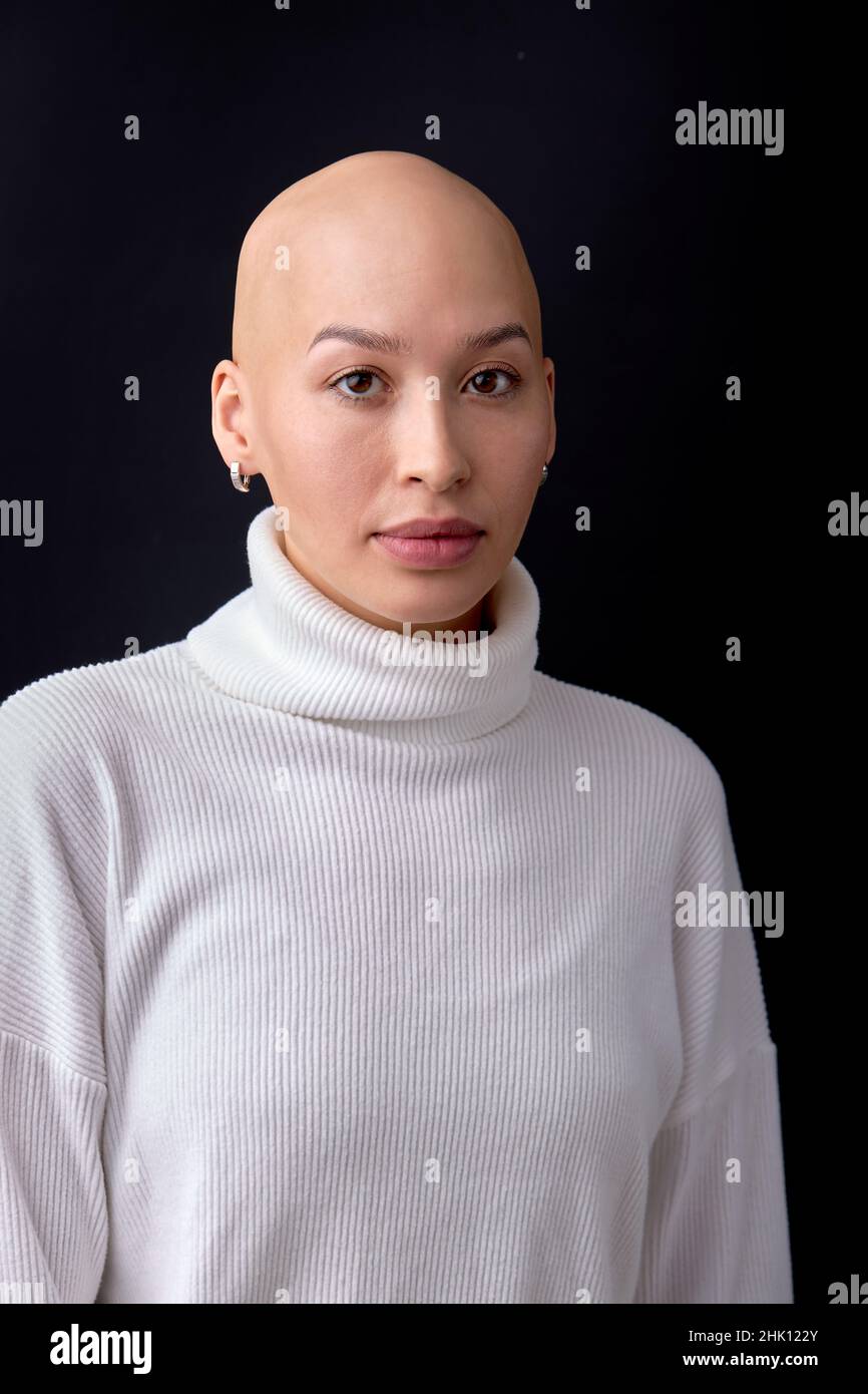 Portrait of hairless female in white casual shirt looking at camera ...