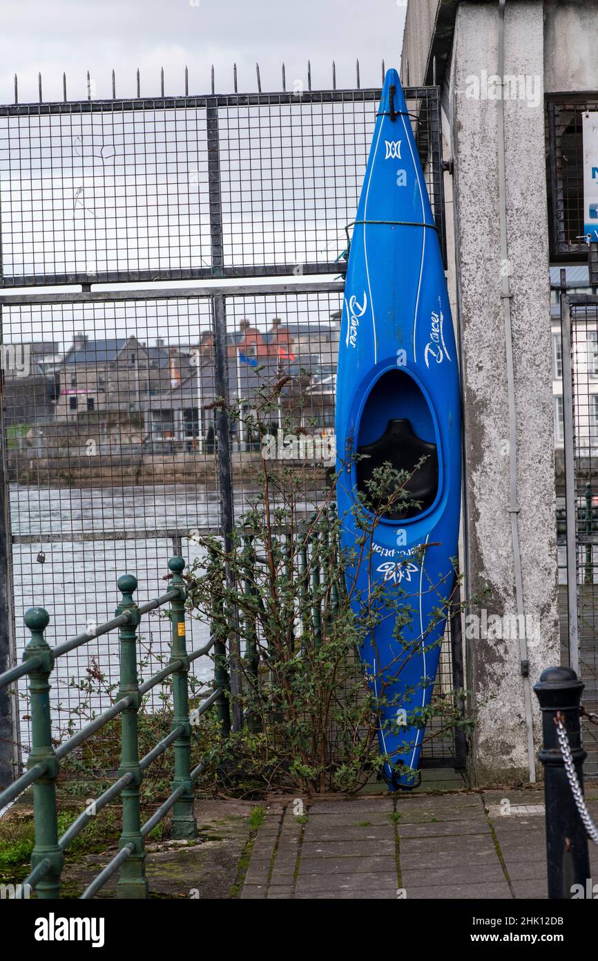 A blue water kayak parked vertically on a fence Stock Photo - Alamy