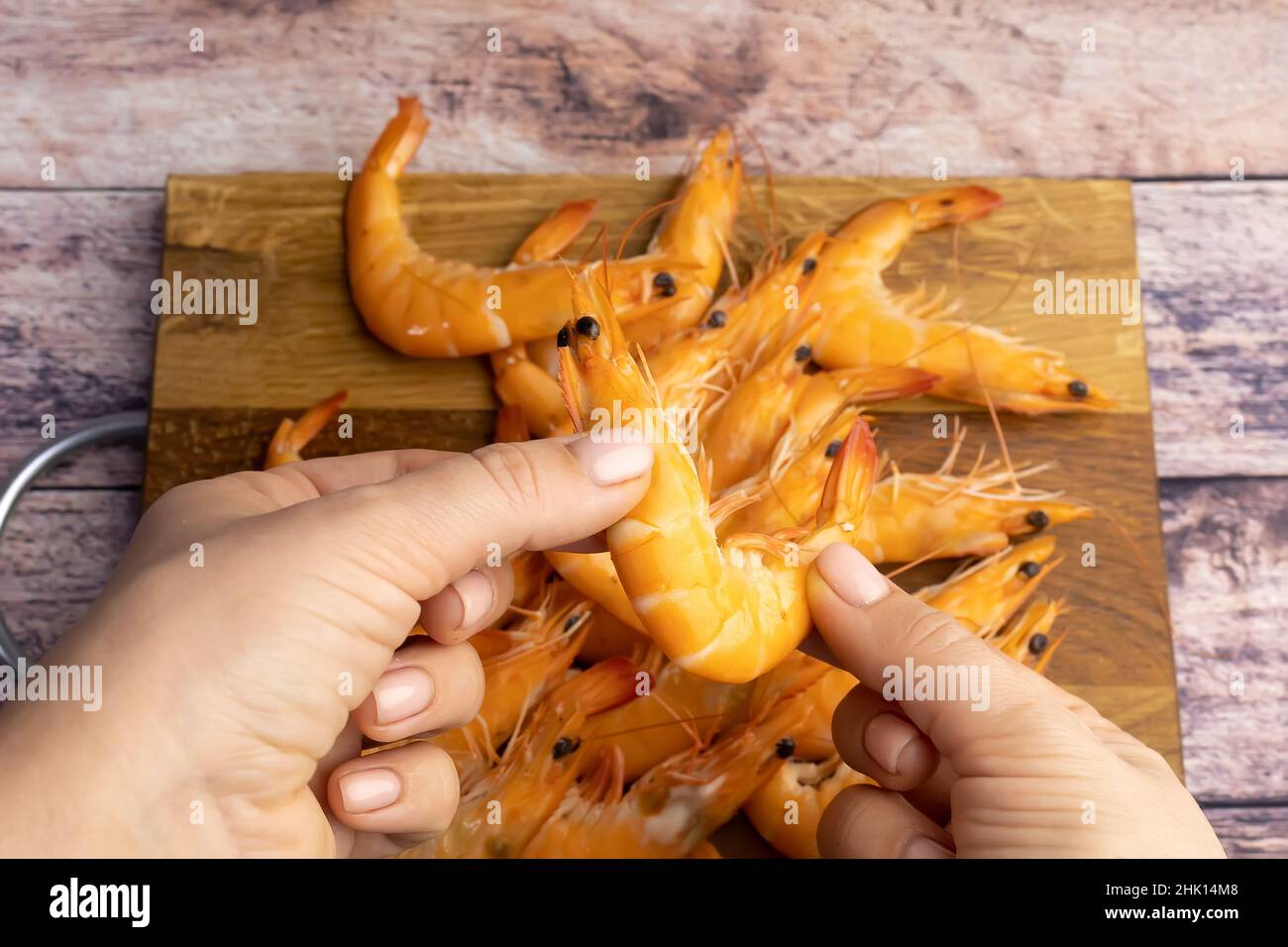 top view of women's hands peeling boiled shrimp from the shell Stock ...