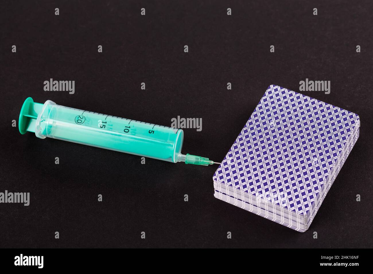 Syringe and playing cards as a vice. Located on a black background ...