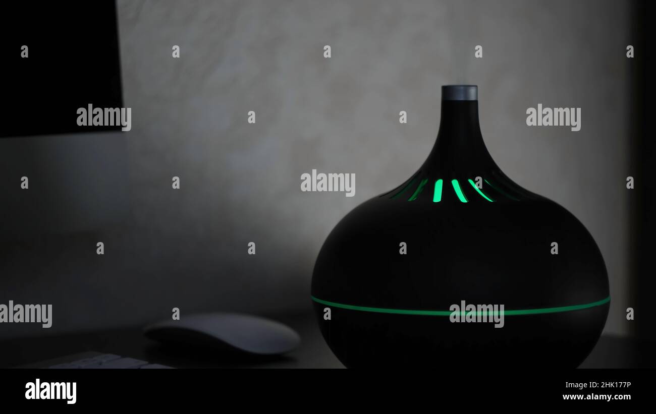 Workplace humidifier. Action. Modern luminous humidifier on desktop ...