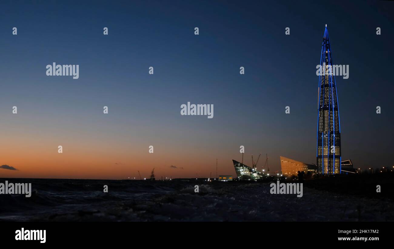 View of the skyscraper by the river in the evening. Concept. Beautiful ...