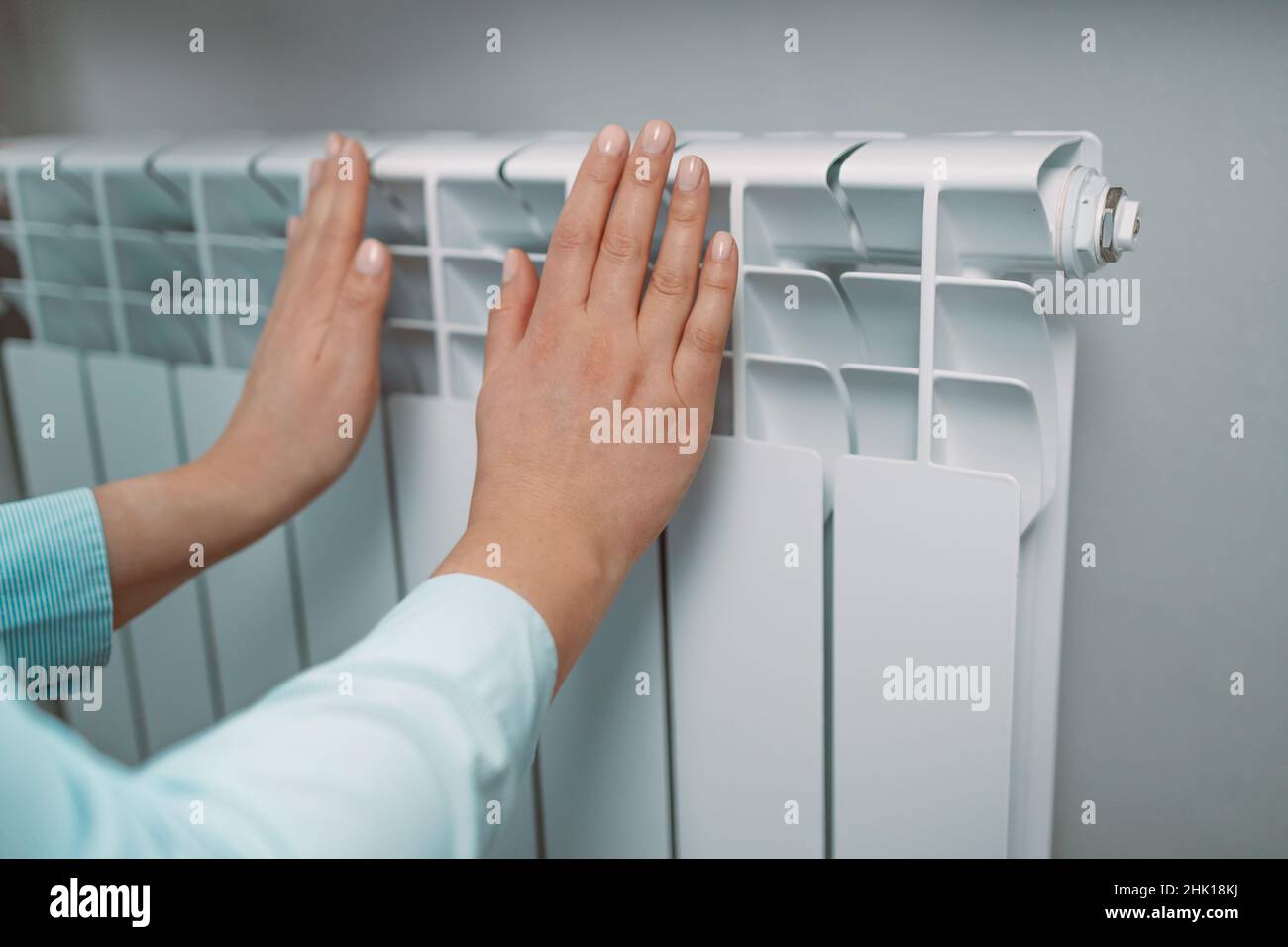 Female touching barely warm battery during heating season. Heating ...