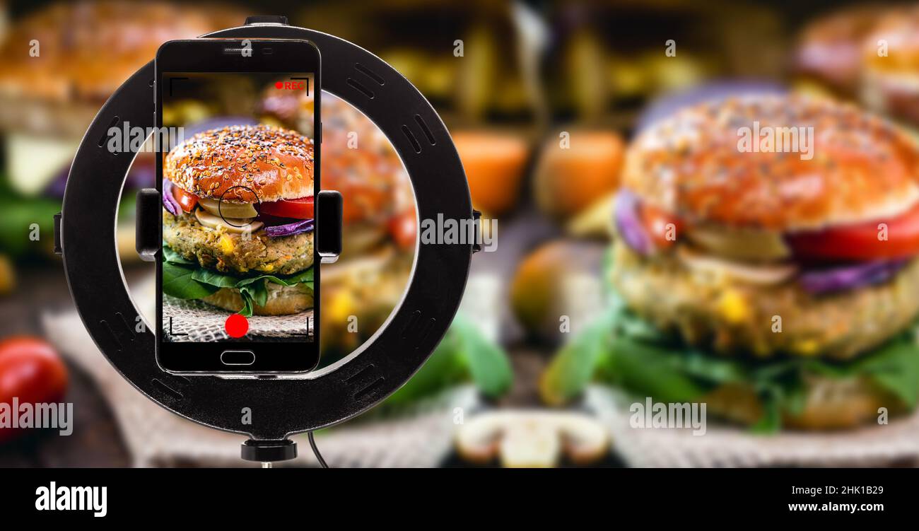 Burger being filmed with cell phone, smartphone recording video with ...