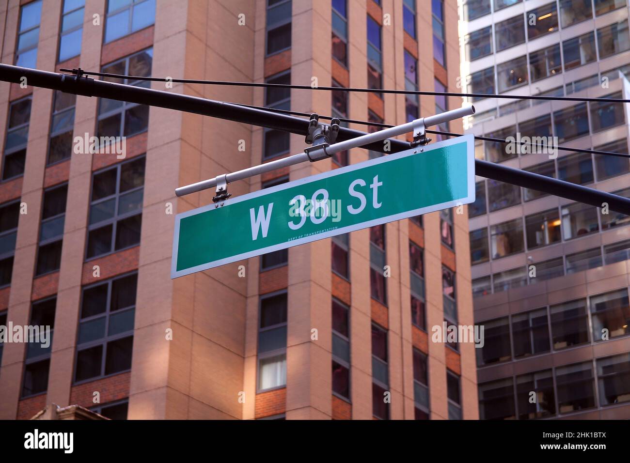 Green big West 38th Street sign hanging on a arch pole in the streets ...